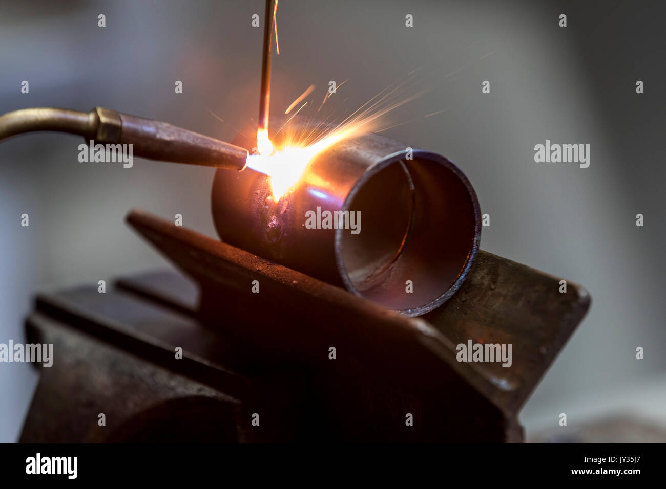 Welding, with a welding torch two metal pipes are welded, training ...