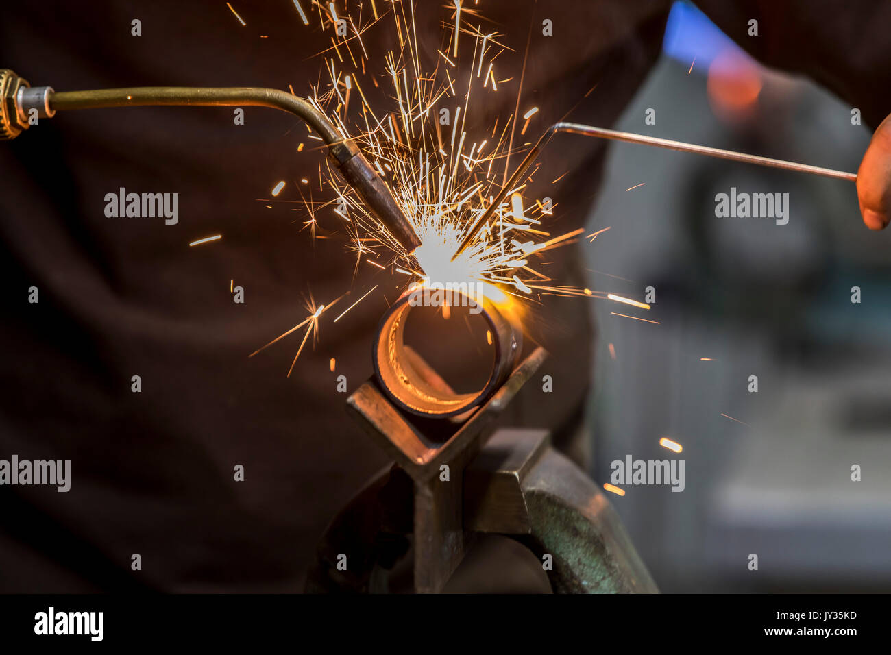 Welding, with a welding torch two metal pipes are welded, training ...