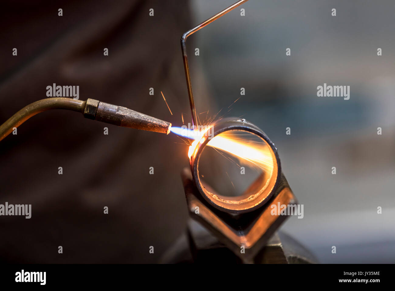 Welding, with a welding torch two metal pipes are welded, training ...