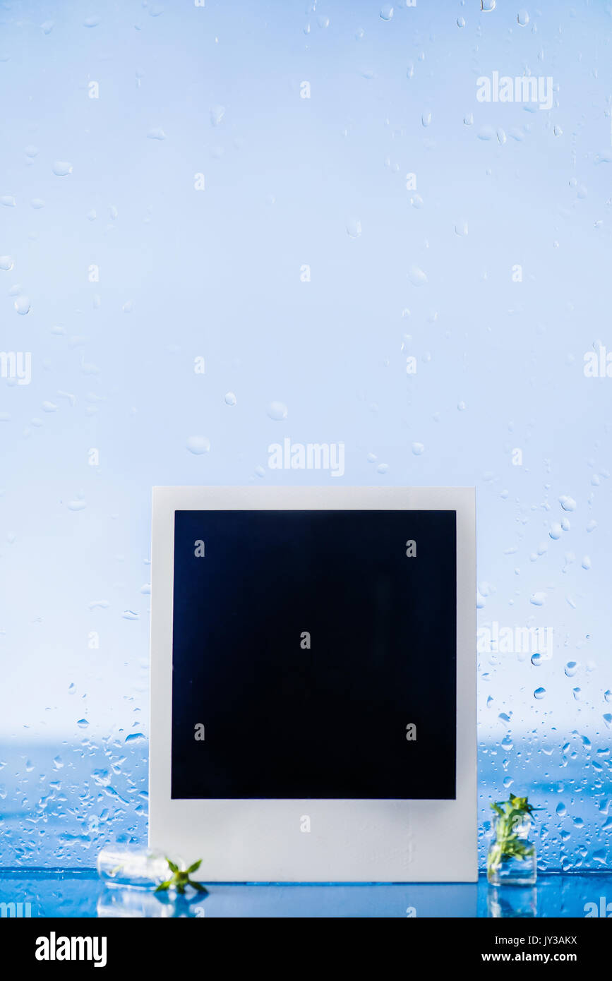 Simple still life with instant photo frame, summer rain, drops on a ...