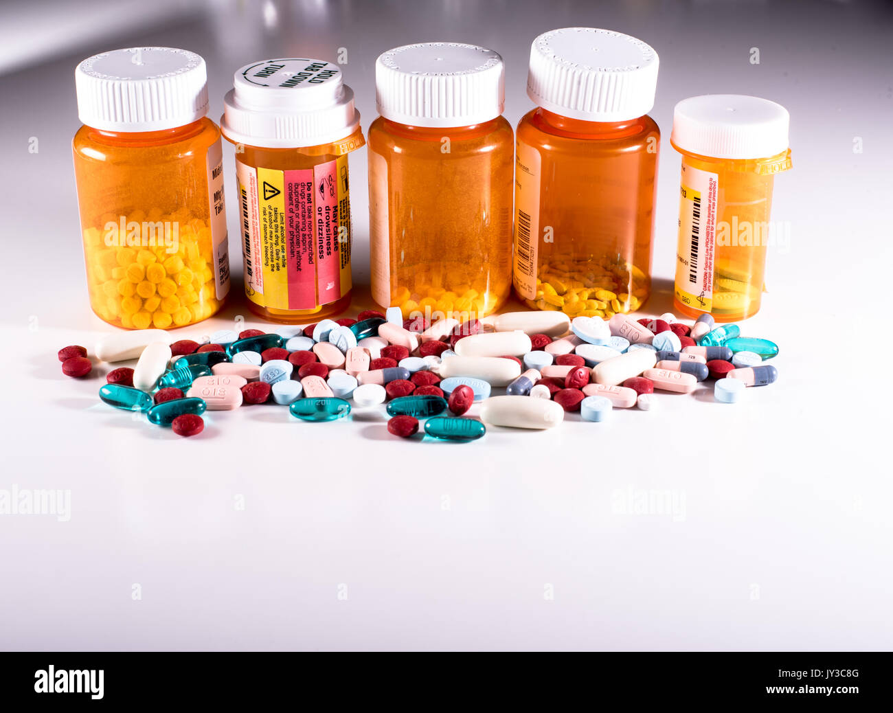 A pile of assorted medications in front of five pill bottles Stock ...
