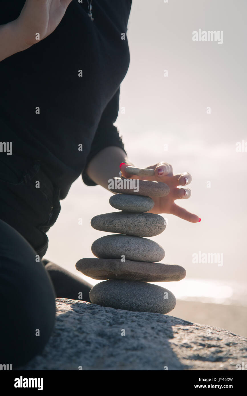 Woman stacking stones hi-res stock photography and images - Alamy