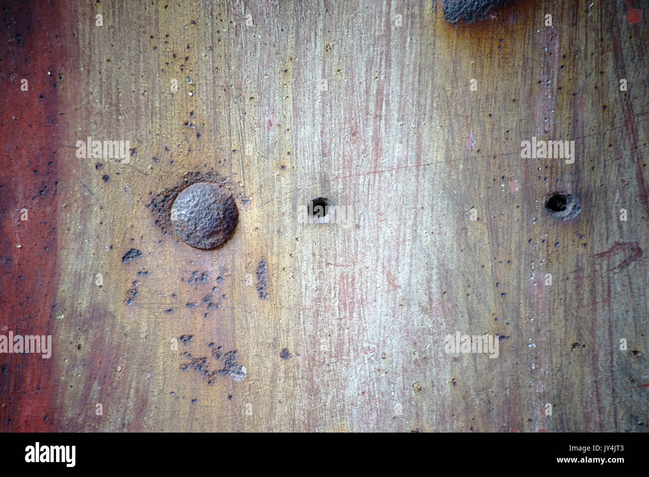 The closeup of a rusty metal surface with rust bubbles and rusty rivets ...