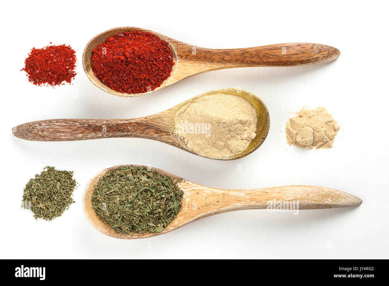 An overview of wooden spoons filled with red pepper powder, garlic ...