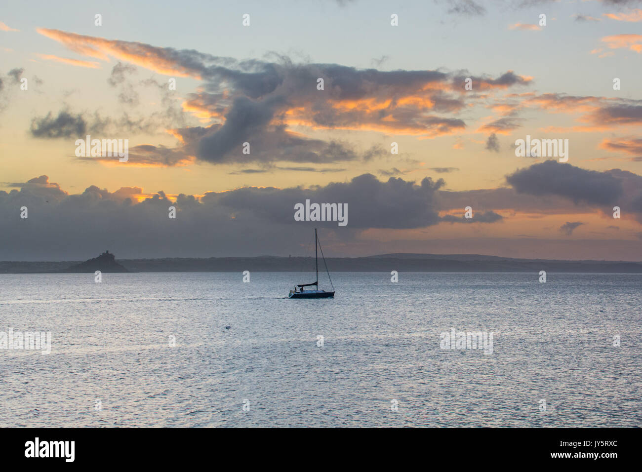 Yacht setting off from Newlyn harbour at Dawn on the sea at mounts bay ...