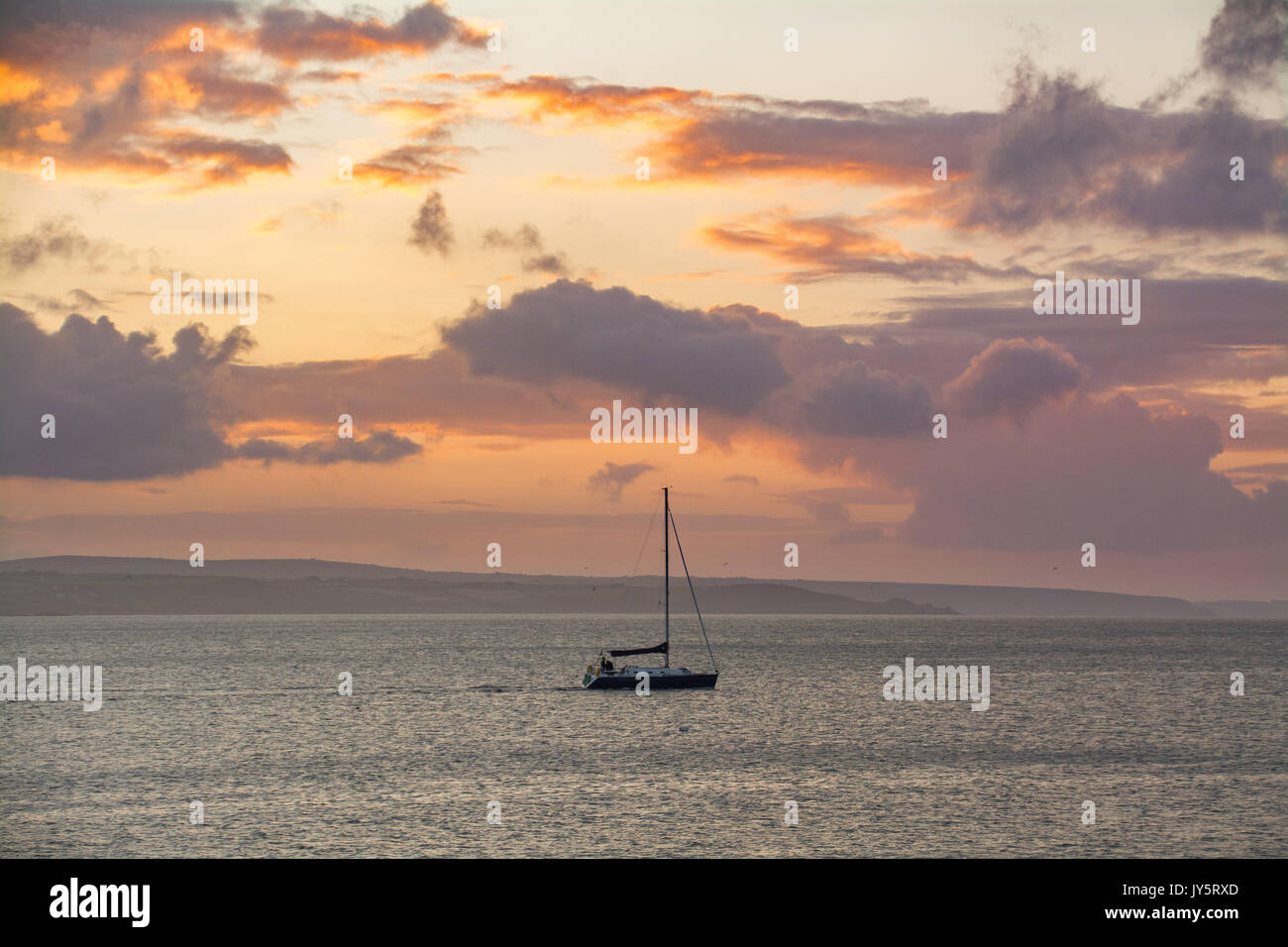 Yacht setting off from Newlyn harbour at Dawn on the sea at mounts bay ...
