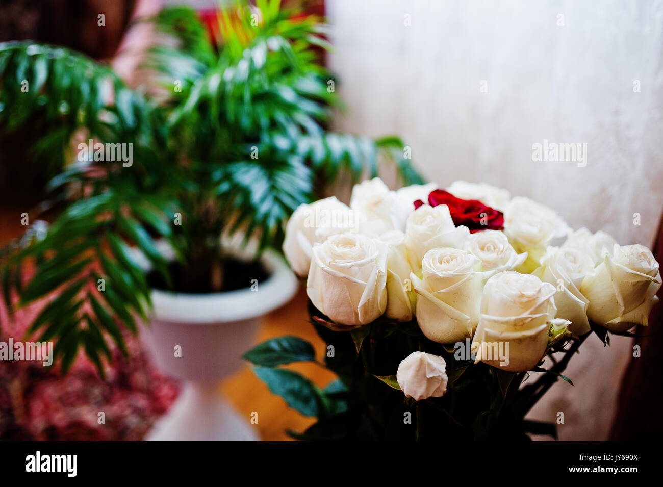 Close-up photo of a bouquet made out of white roses and one red rose ...