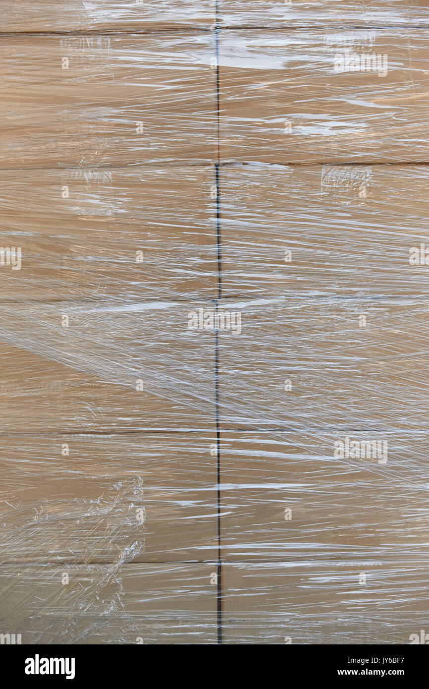 Shrink wrapping on a stacked cardboard boxes. Delivery background Stock ... Shrink wrapping on a stacked cardboard boxes. Delivery background Stock ...