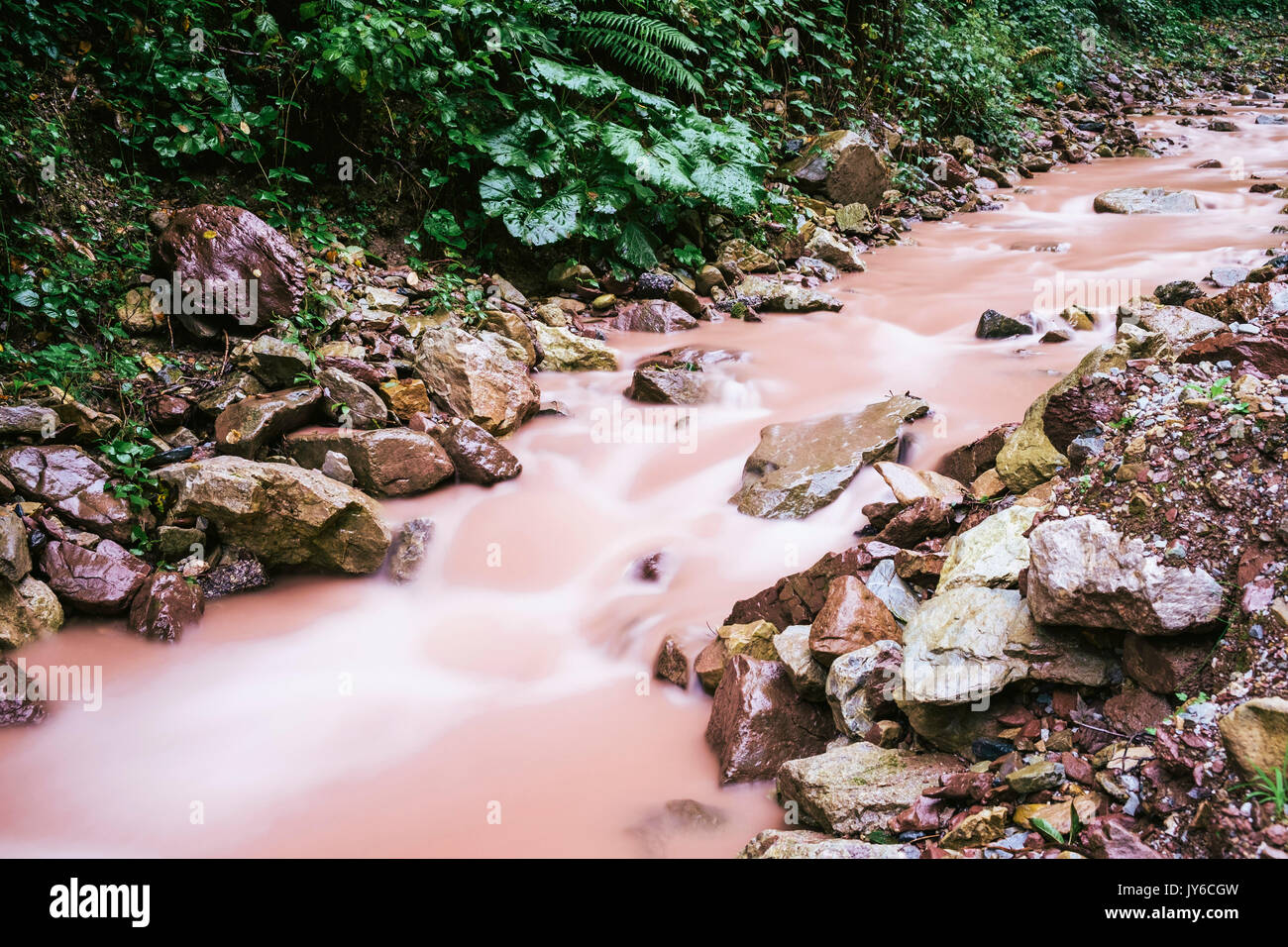 Red colored water stream caused by red dirt Stock Photo - Alamy