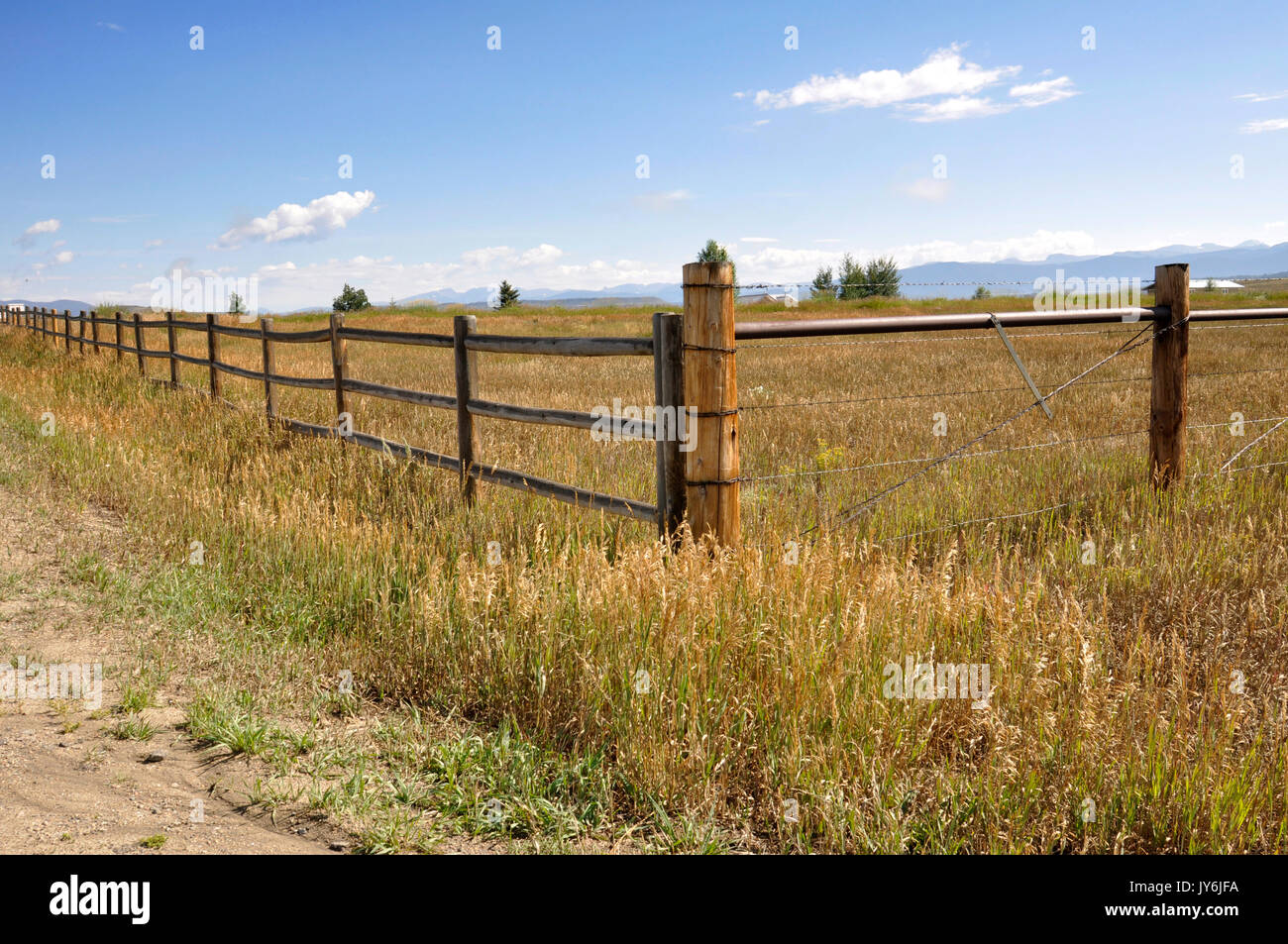 wood and wire fence by a prairie in Colorado. The Rockie Mountains are ...