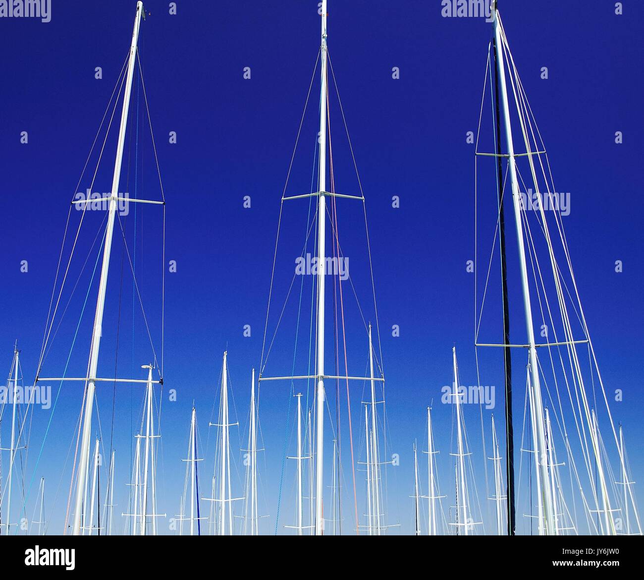 Artistic. Yacht Masts of boats berthed at a marina reaching into a ...