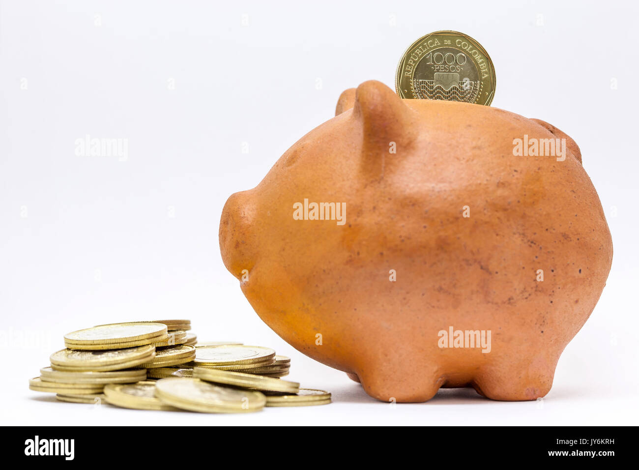 Saving money into a traditional clay piggy bank Stock Photo - Alamy