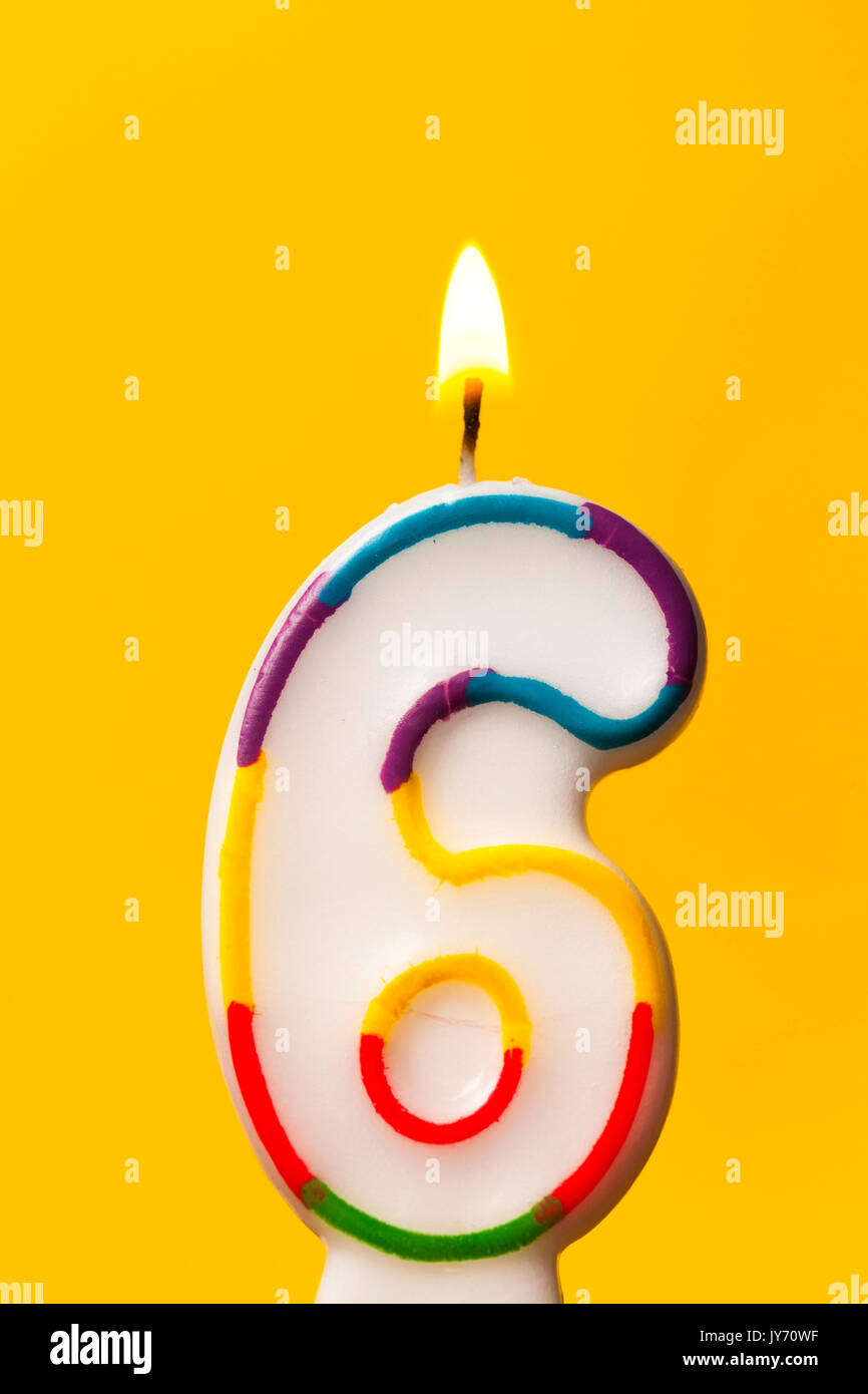 Number 6 birthday celebration candle against a bright yellow background ...