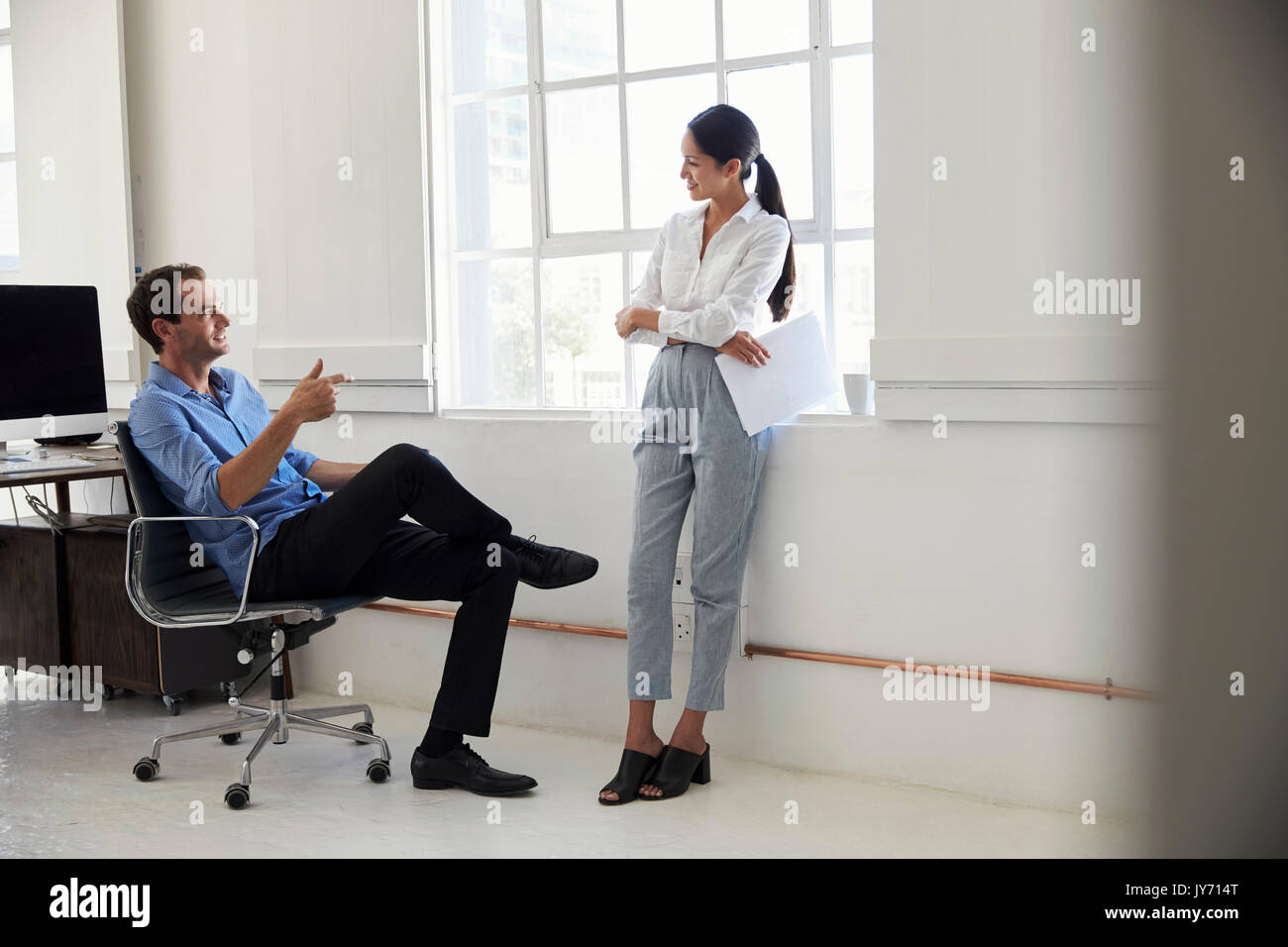 Two business colleagues chatting in an office Stock Photo - Alamy