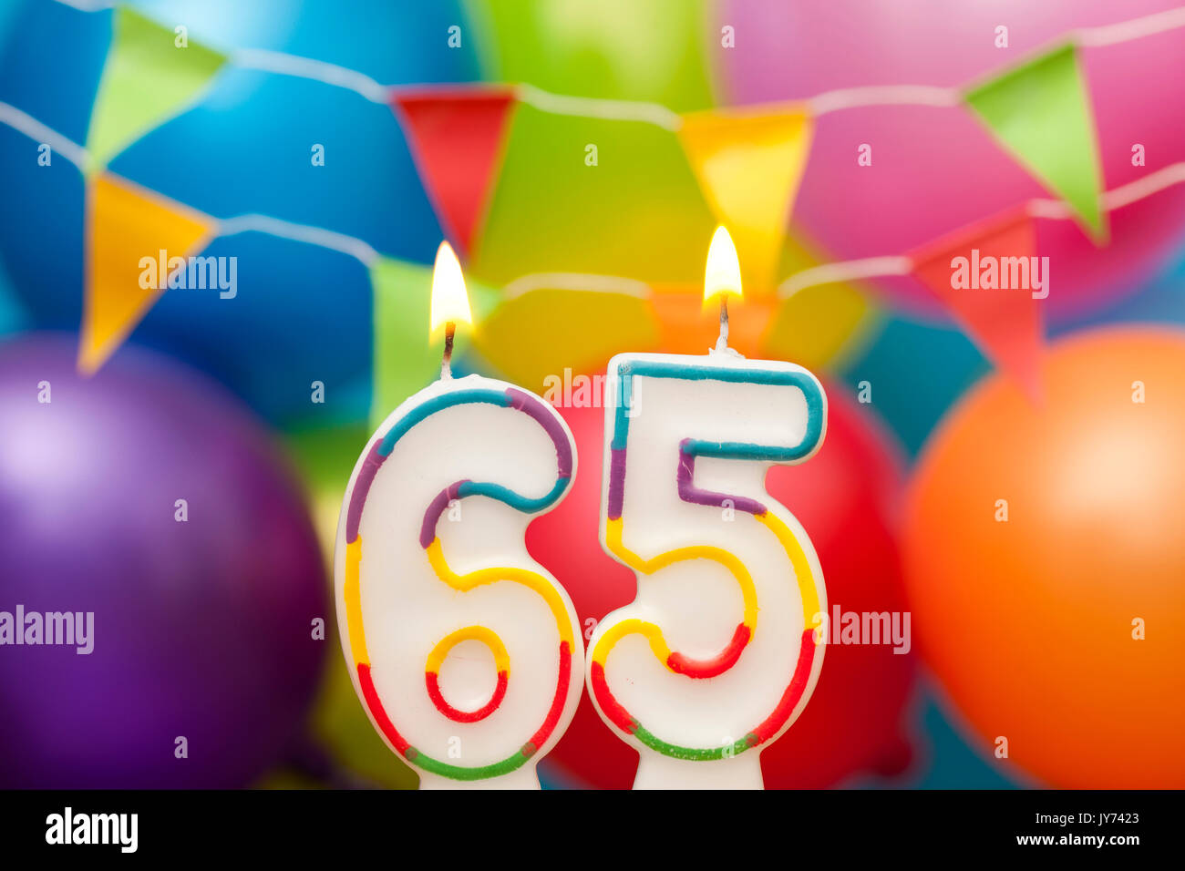Happy Birthday number 65 celebration candle with colorful balloons and ...