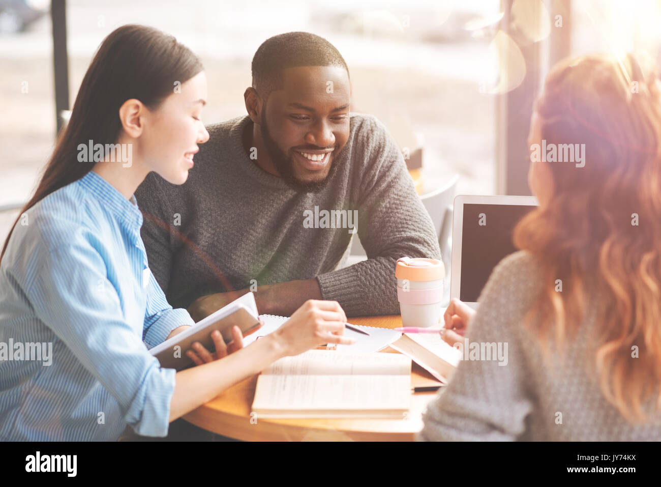Positive international students studying in the cafe Stock Photo - Alamy