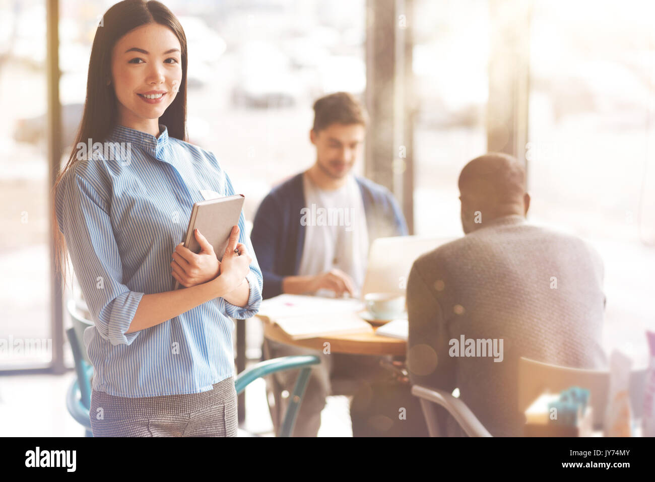 Positive female student holding a book Stock Photo - Alamy