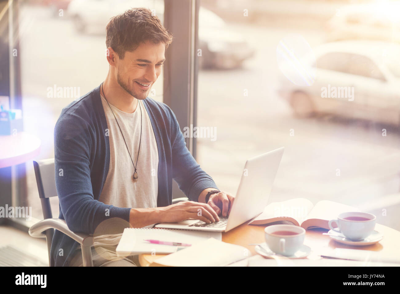 Positive freelance student sitting in the cafe Stock Photo - Alamy