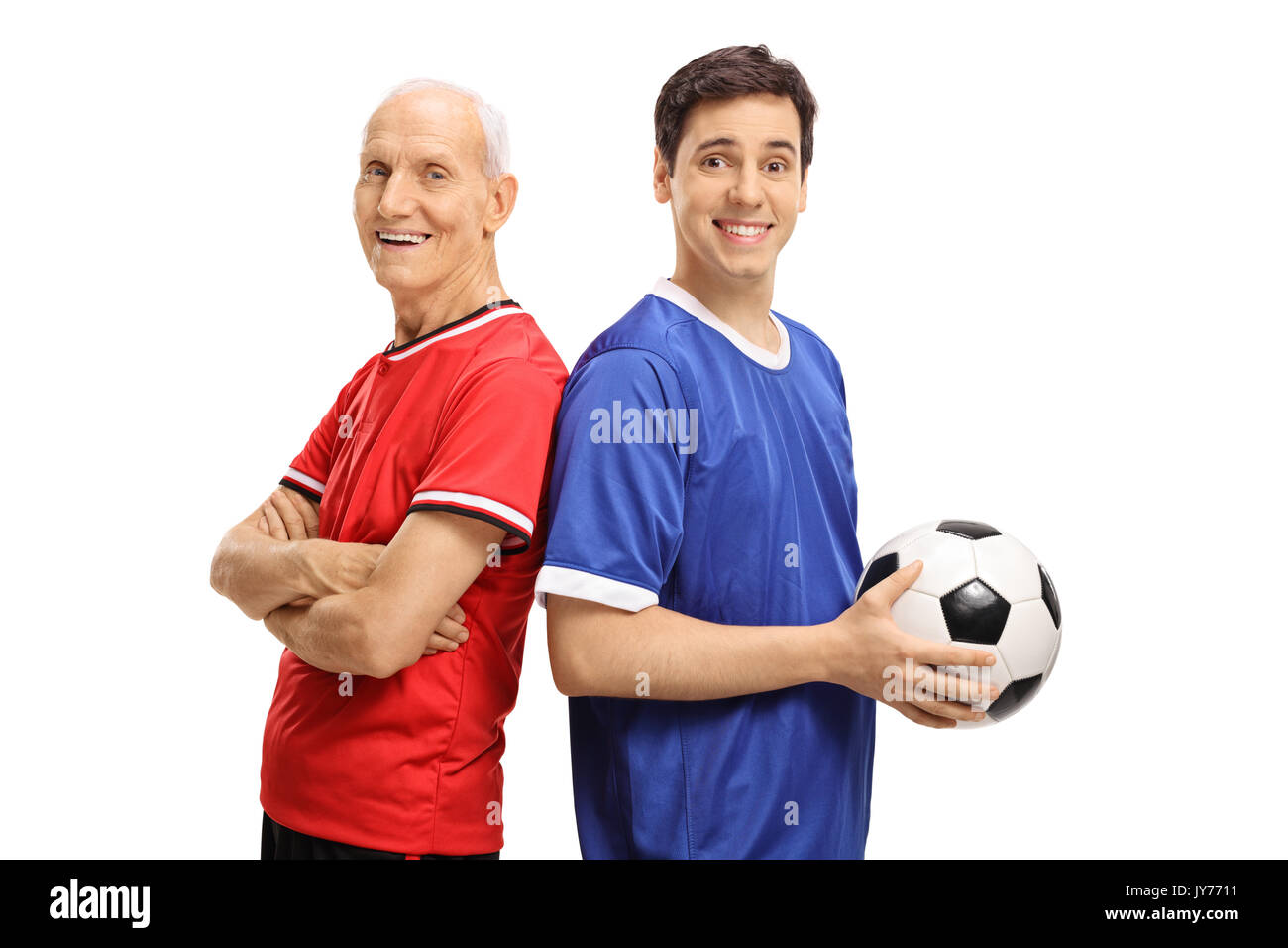 Elderly soccer player and a young player with a football looking at the ...