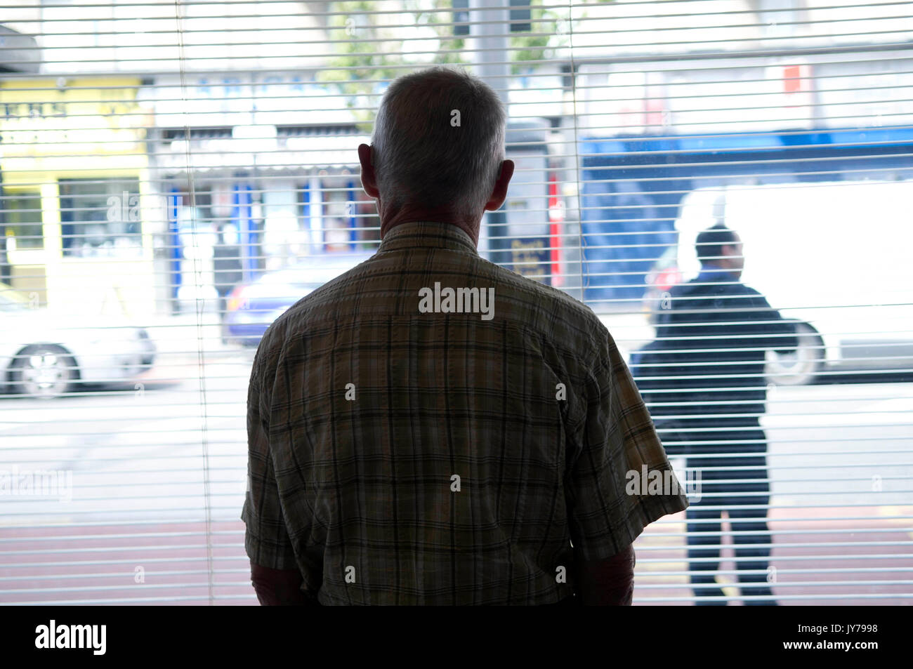 Lonely elderly man looking out of his window Stock Photo - Alamy