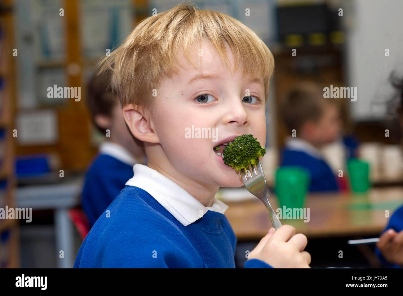 Young school child eating broccoli for lunch at school Stock Photo - Alamy