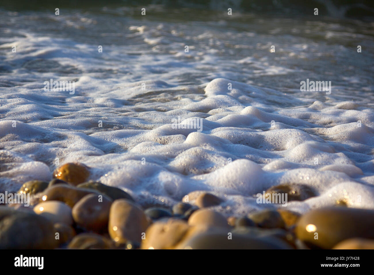 Beach of multi-colored round pebbles, and the splash of salty waves ...