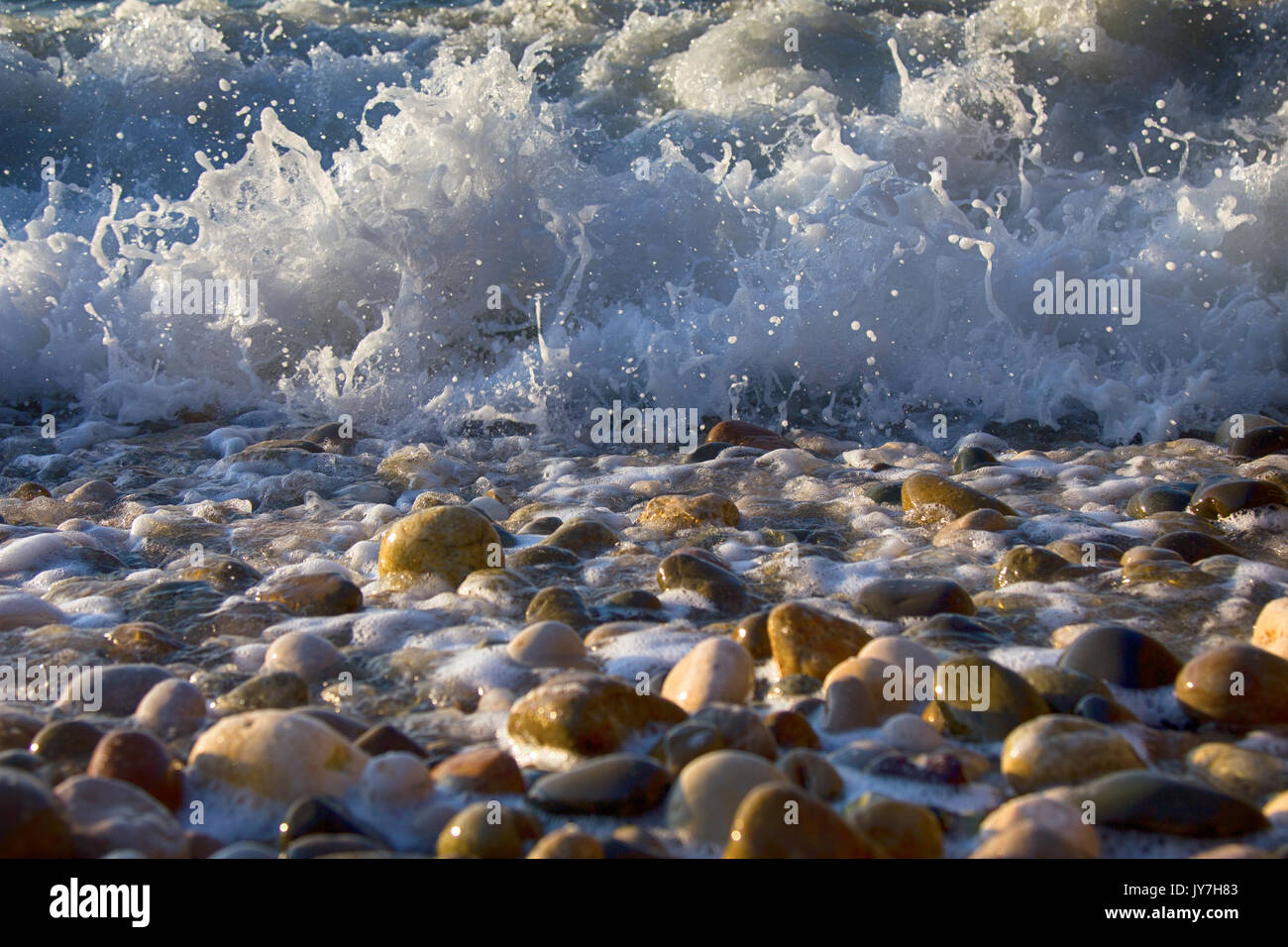 Beach of multi-colored round pebbles, and the splash of salty waves ...