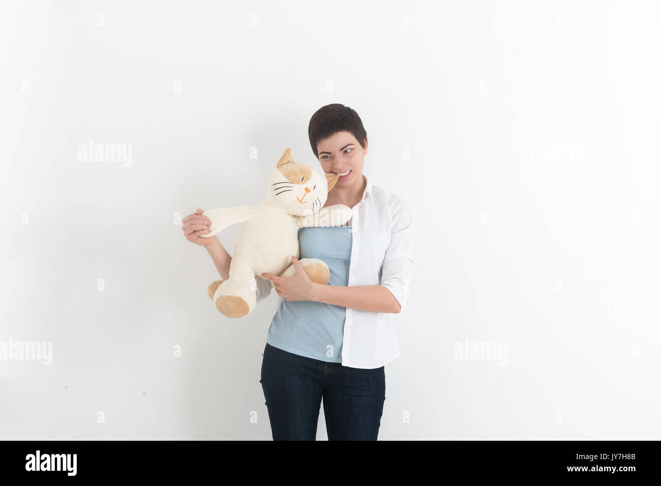 Crazy young woman is biting a plush toy or teddy bear Stock Photo - Alamy