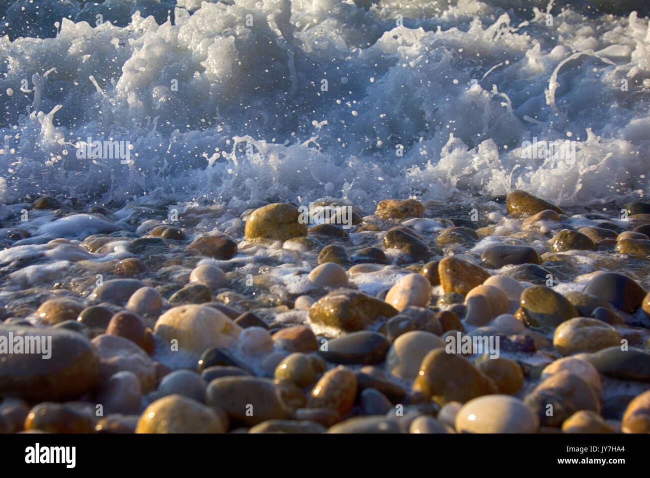 Beach of multi-colored round pebbles, and the splash of salty waves ...
