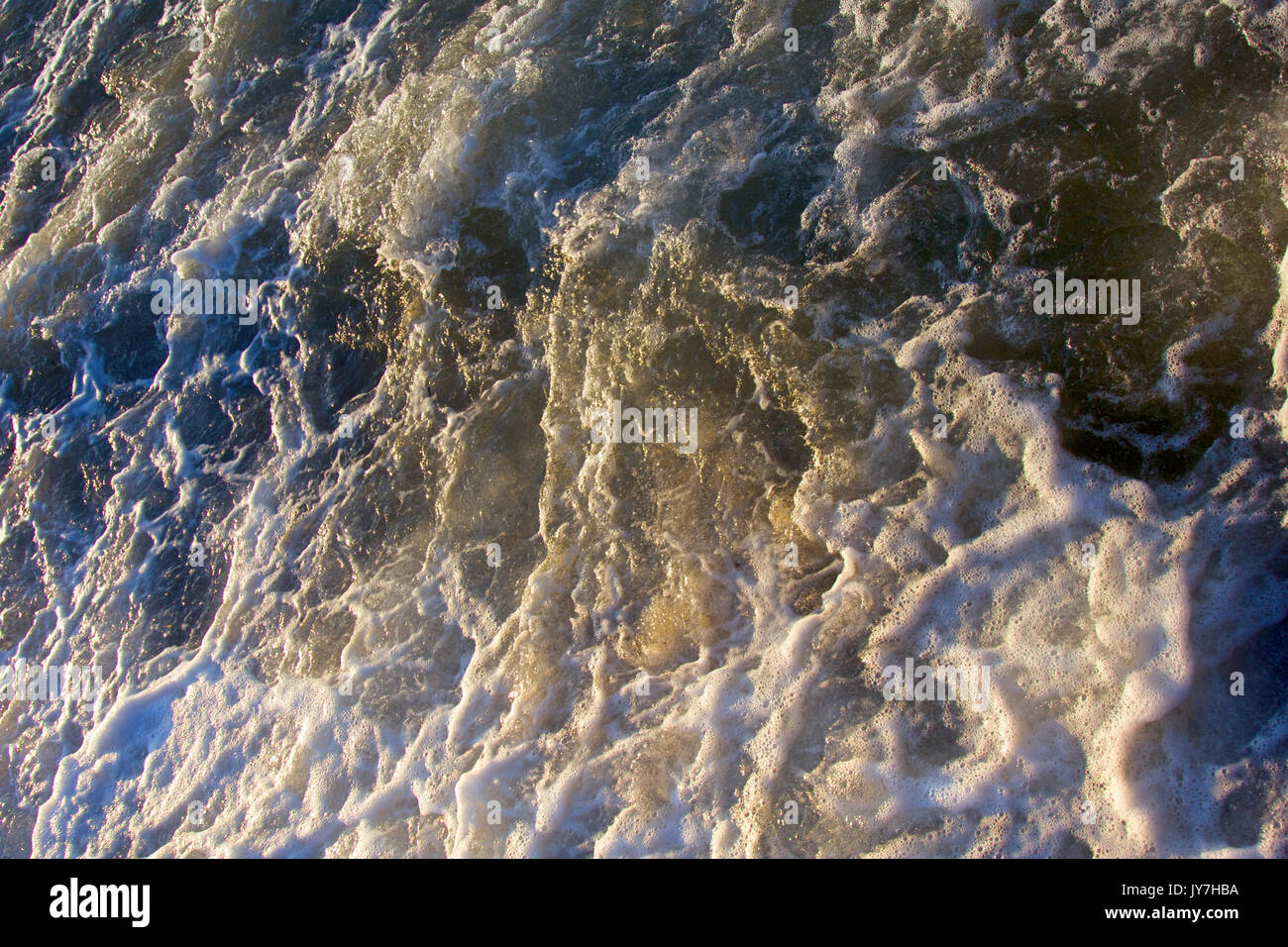 Sea rolling and receding water in rays of setting sun. Black sea ...