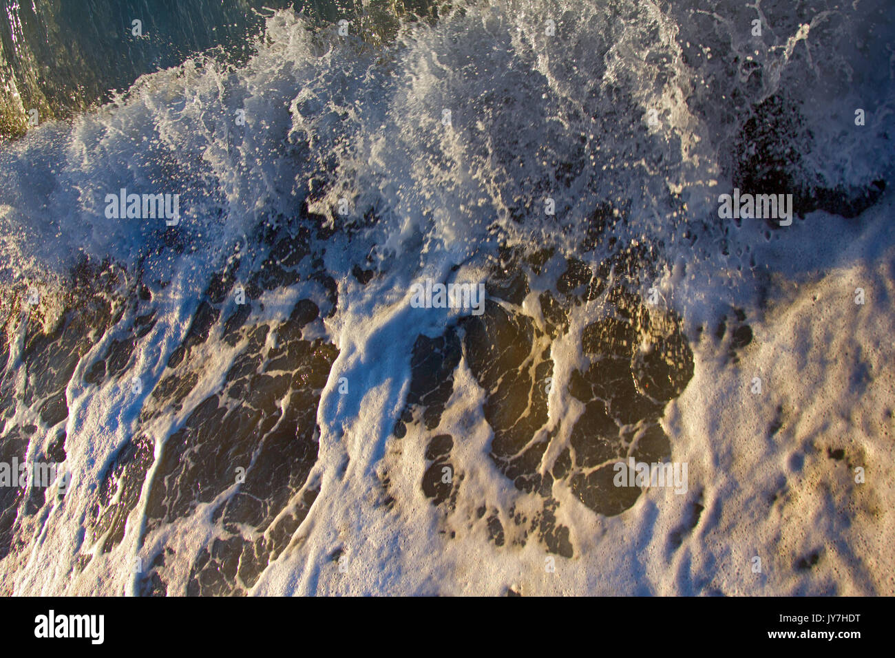 Sea rolling and receding water in rays of setting sun. Black sea ...