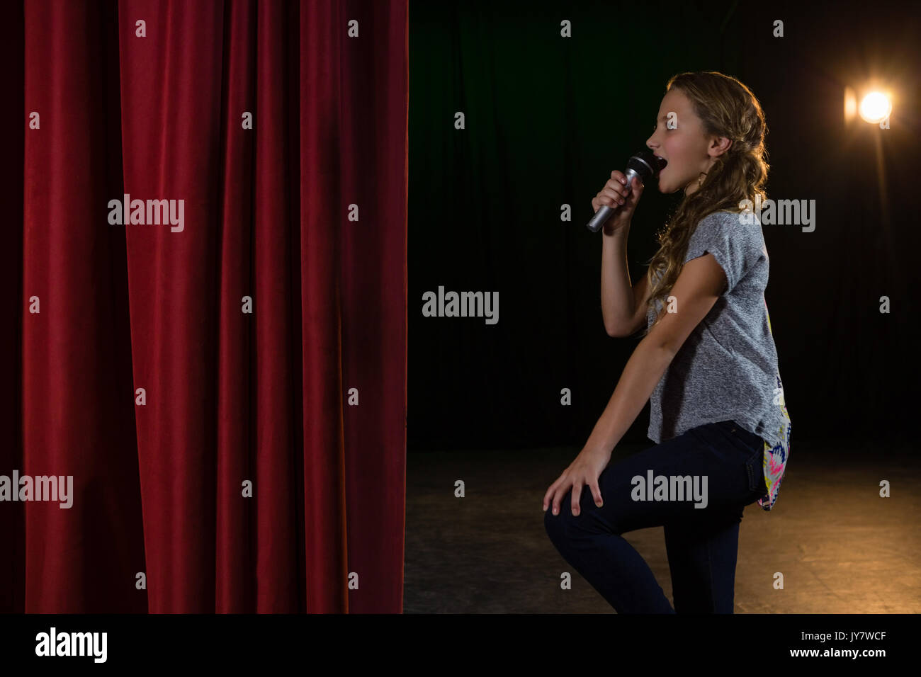 Female artist singing song on stage in theatre Stock Photo - Alamy