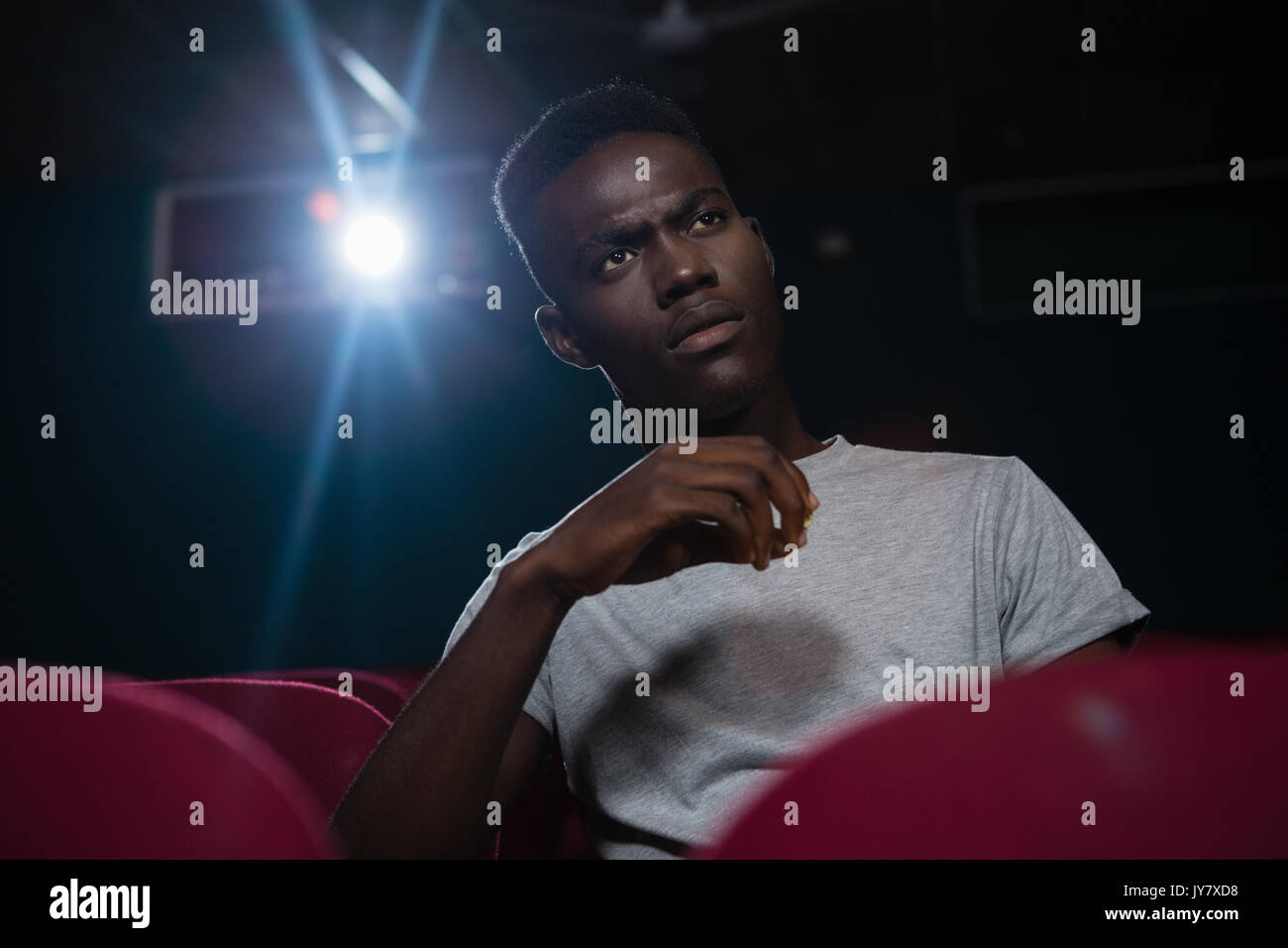 Concentrated man watching movie in theatre Stock Photo - Alamy