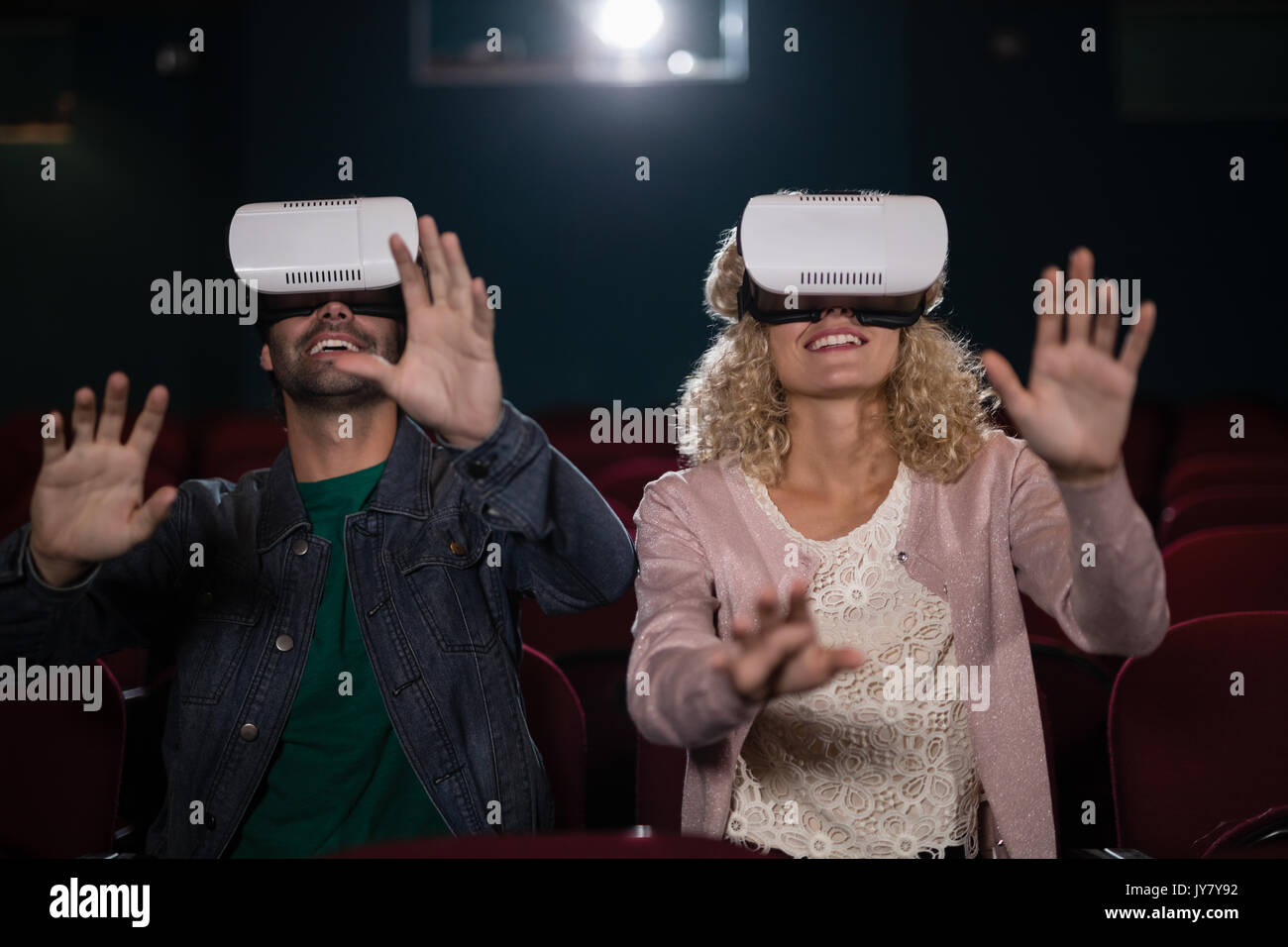 Couple using virtual reality headset in theatre Stock Photo - Alamy