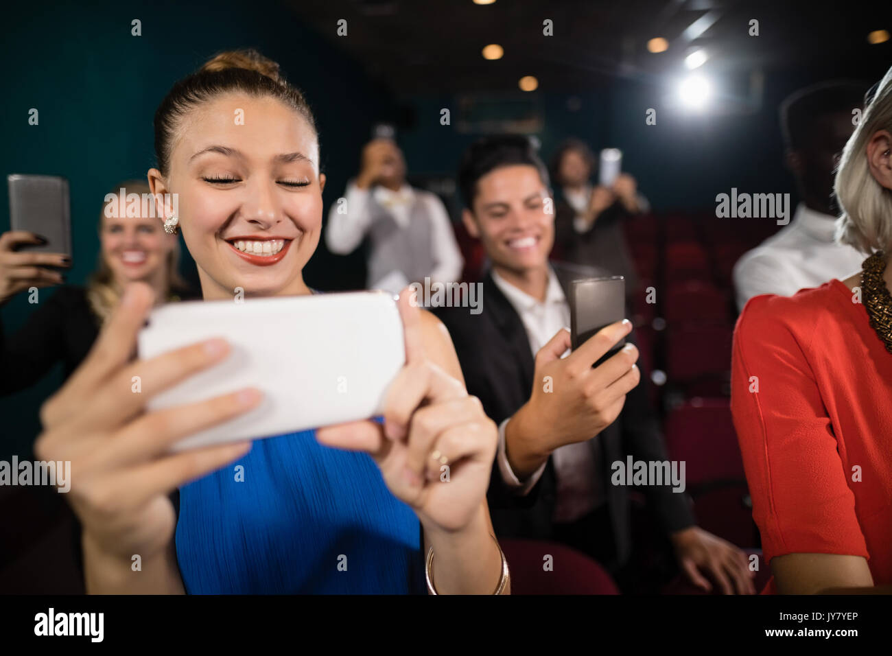 Group of people clicking photographs in movie theatre Stock Photo - Alamy