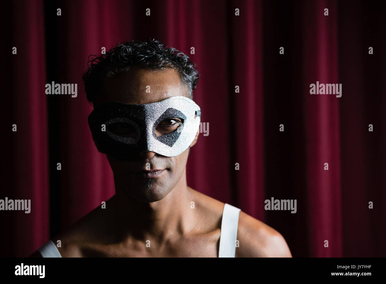 Man wearing masquerade mask in stage Stock Photo - Alamy