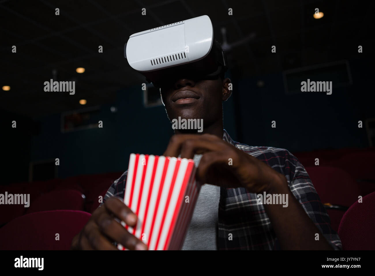 Man using virtual reality headset while watching movie in theatre Stock ...