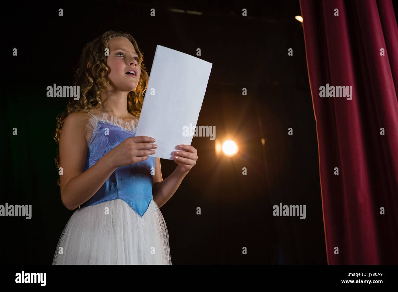 Female artist reading her scripts on stage in theatre Stock Photo - Alamy