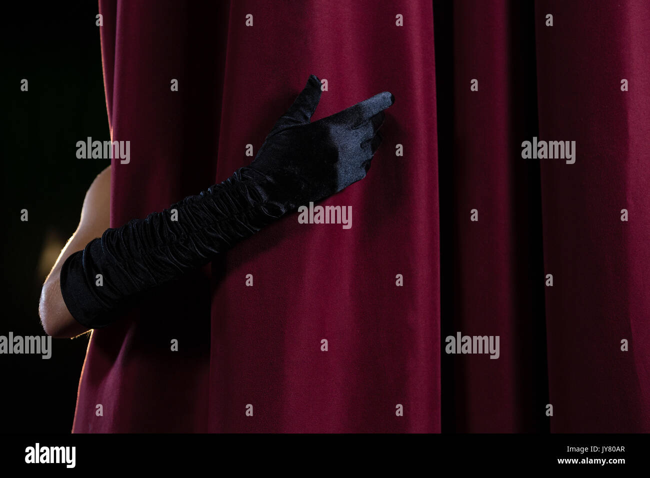 Close-up of hand in a black glove pulling curtain away Stock Photo - Alamy