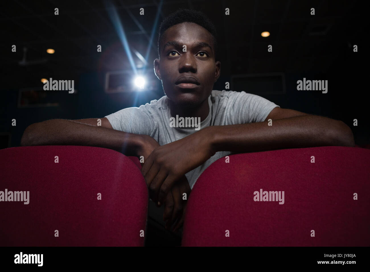 Concentrated man watching movie in theatre Stock Photo - Alamy
