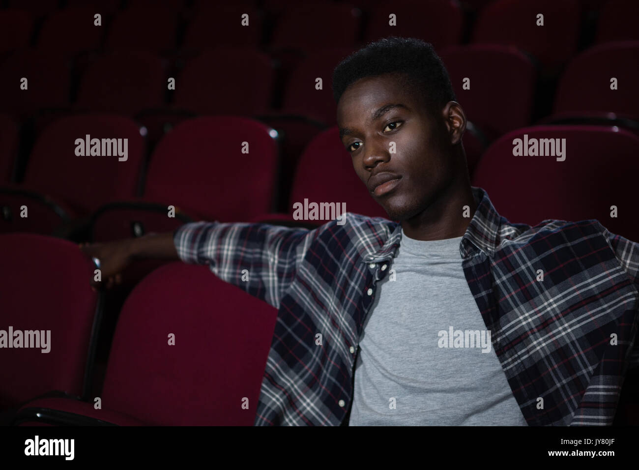 Concentrated man watching movie in theatre Stock Photo - Alamy
