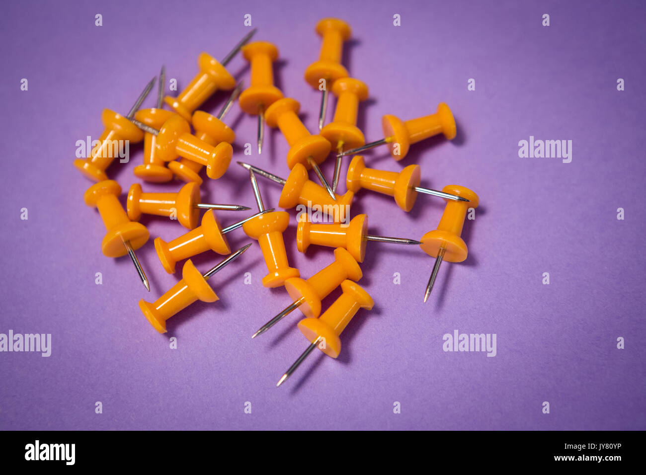 Yellow paper pins on purple paper Stock Photo - Alamy