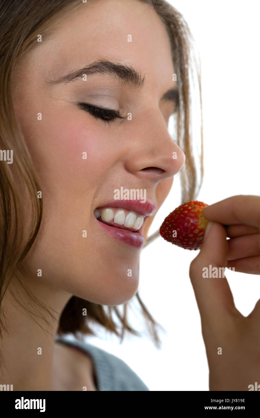 Close up of woman eating strawberry against white background Stock ...