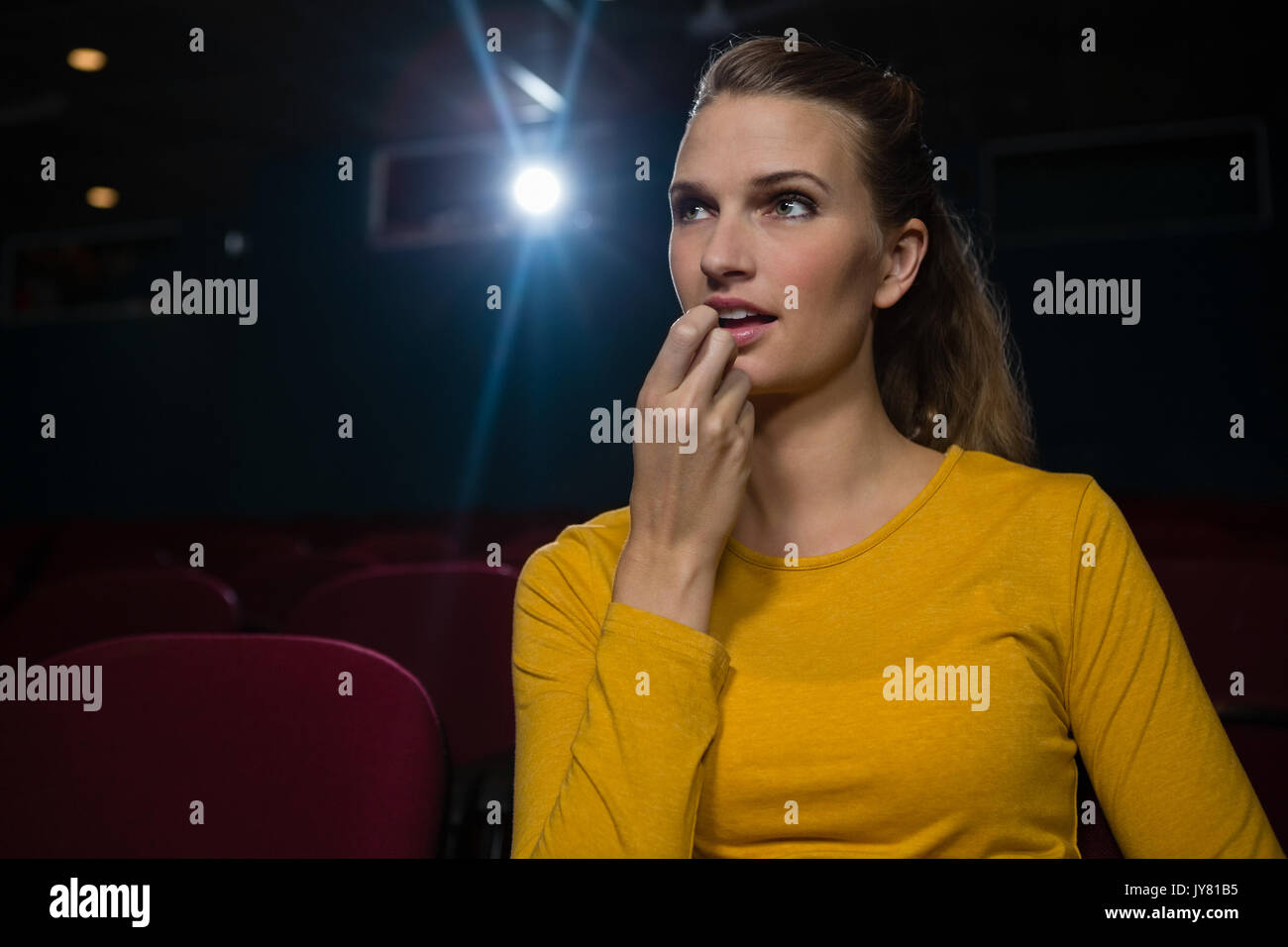 Concentrated woman watching movie in theatre Stock Photo - Alamy