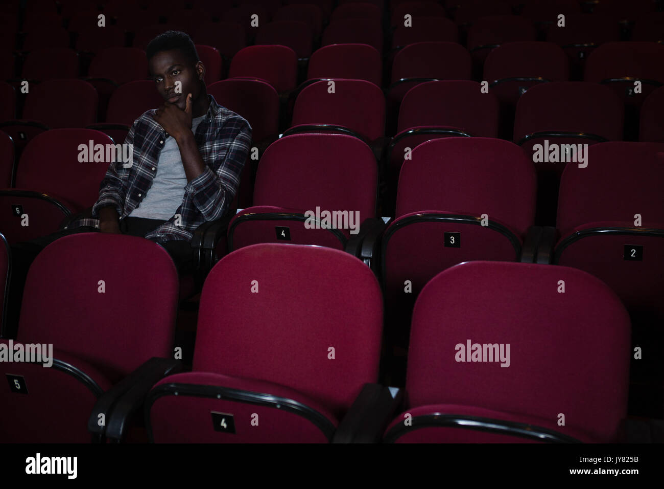 Concentrated man watching movie in theatre Stock Photo - Alamy