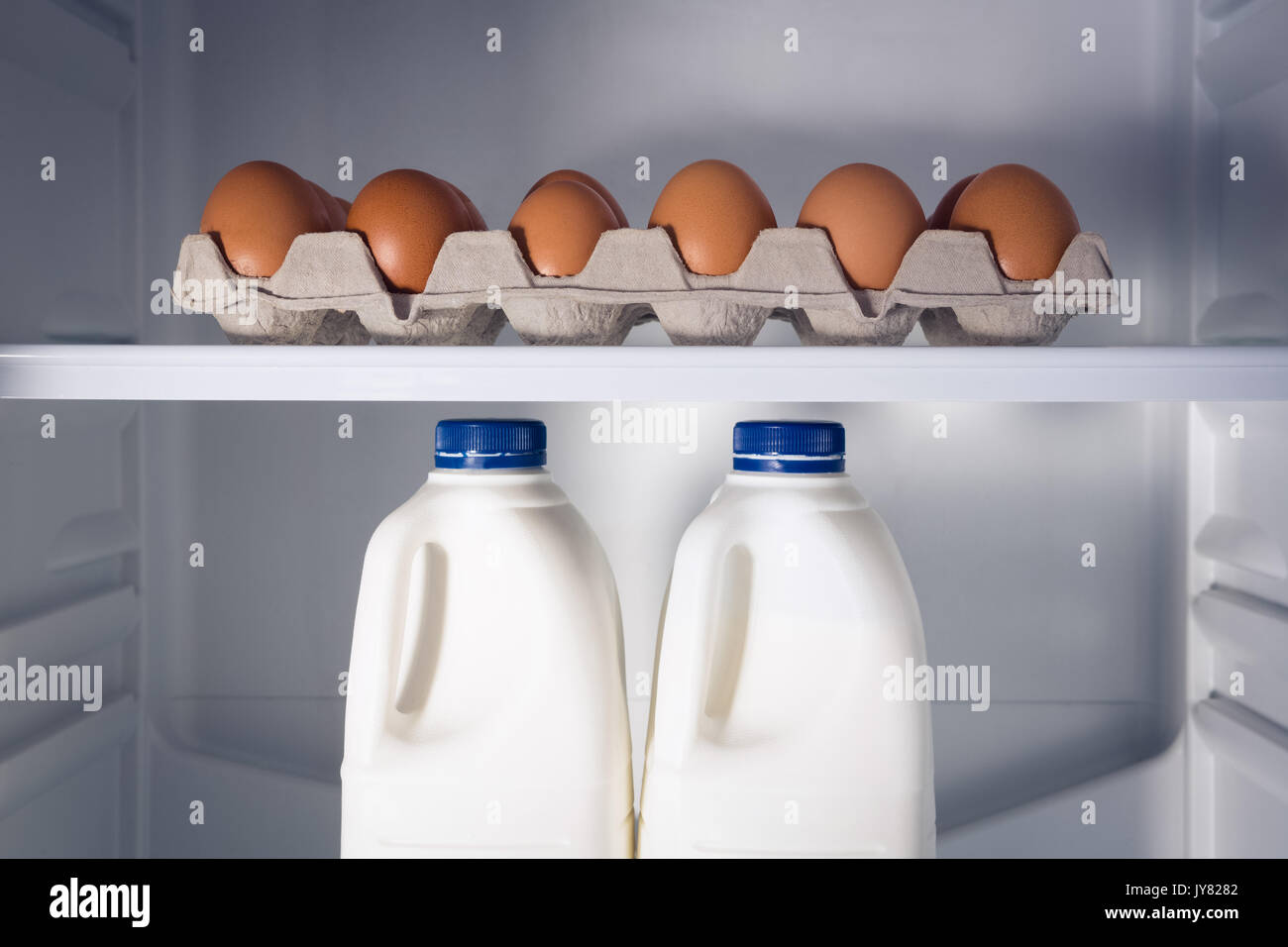 Egg carton and milk bottles in open refrigerator Stock Photo - Alamy