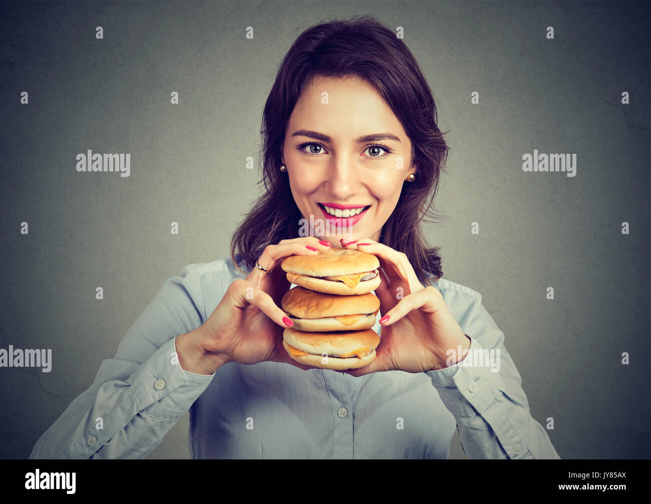 Hungry woman with a tasty triple burger Stock Photo - Alamy