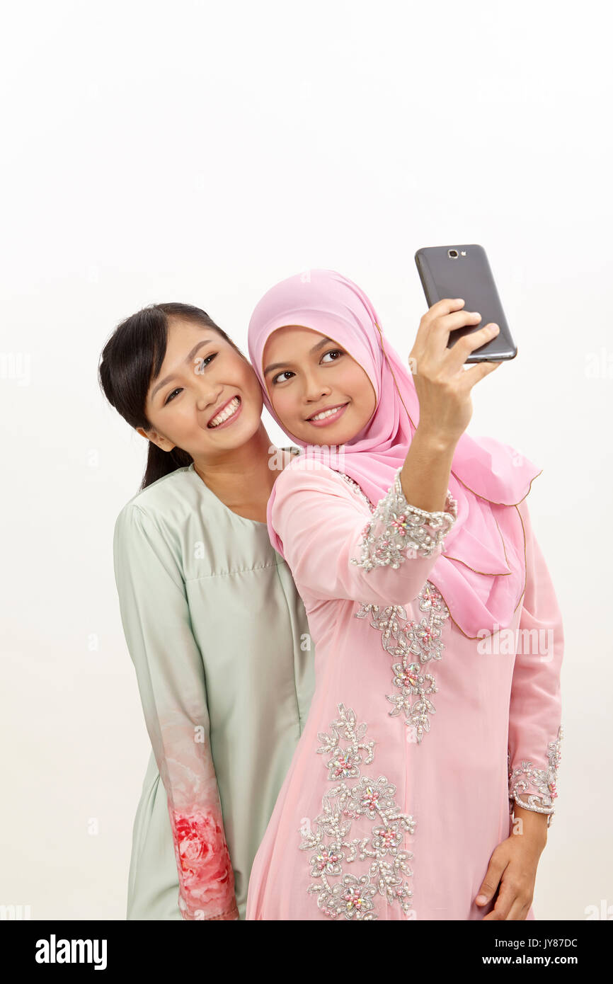 two happy young muslim woman take self portrait with handphone Stock ...