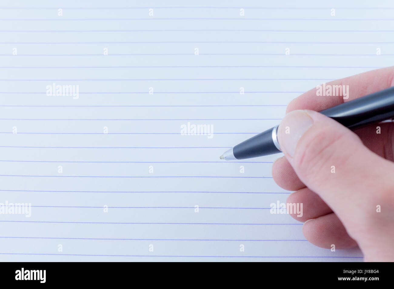 pen in hand writing on lines paper Stock Photo - Alamy
