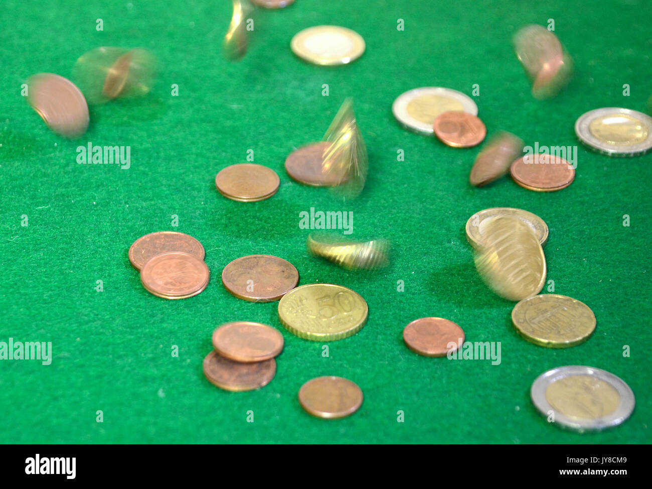 Falling and bouncing Euro coins on a green felt table Stock Photo - Alamy